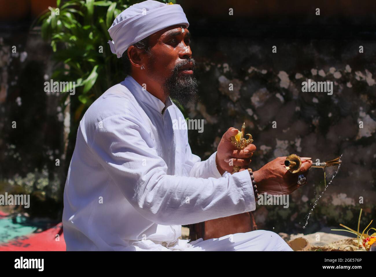 Close up of a Balinese pedanda during prayer. side view of a hindu ...
