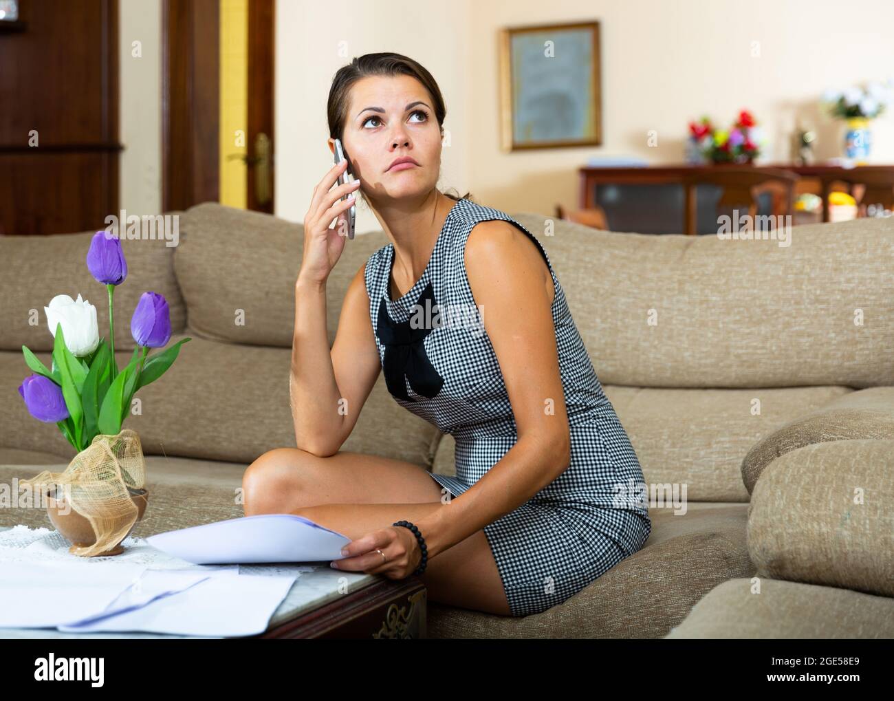 Girl filling out documents and talking on phone Stock Photo - Alamy