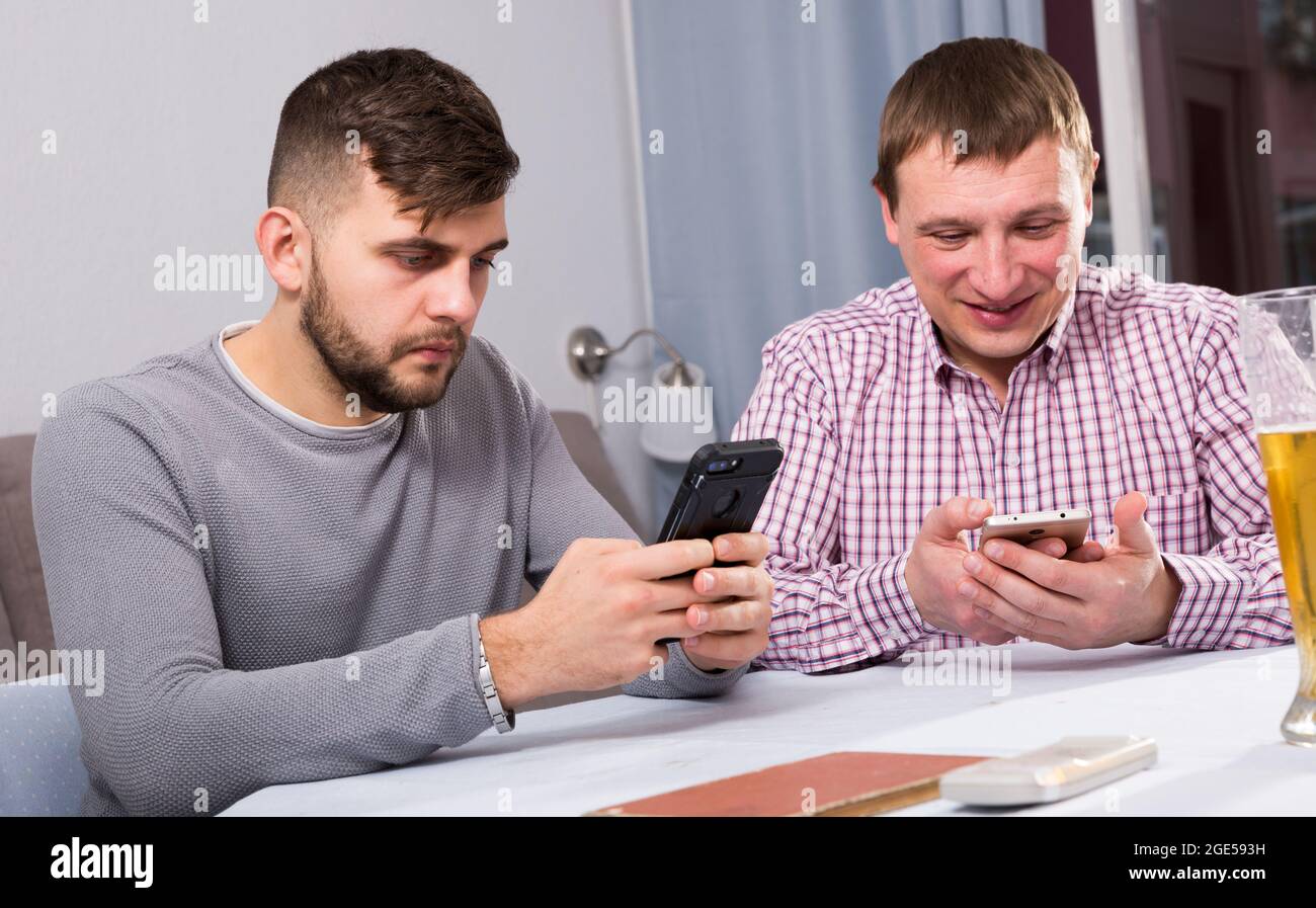 Two men with smartphones at home Stock Photo - Alamy