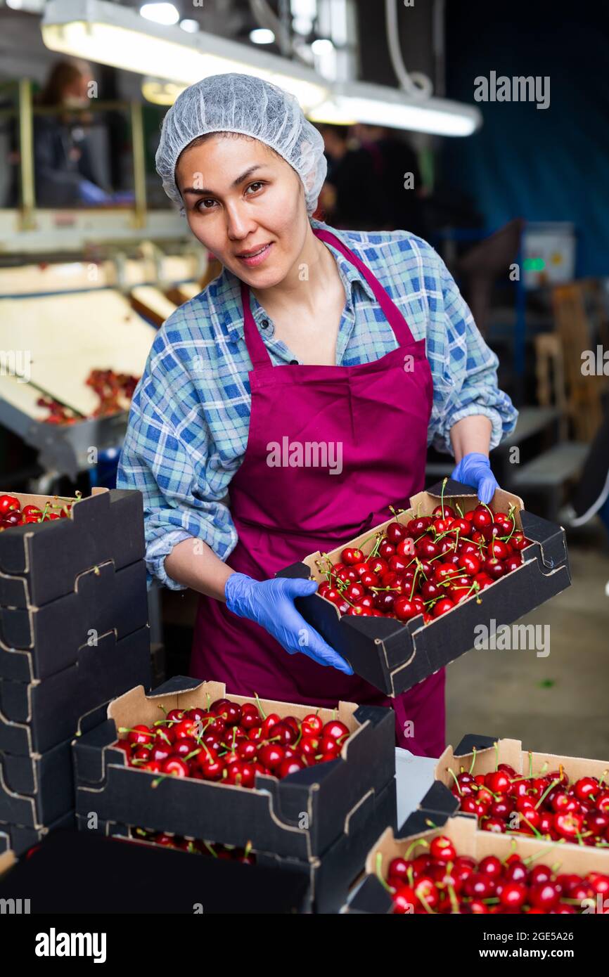 Woman in cherry warehouse Stock Photo - Alamy