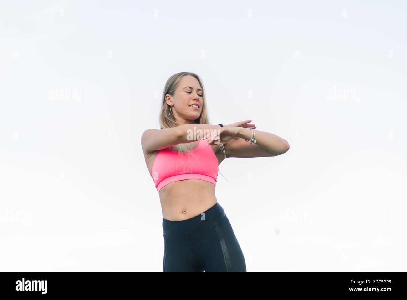 A female coach with dark hair stands on red running track of stadium ...