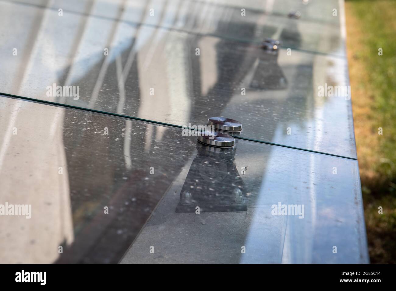 Glass facade panels and stainless steel fasteners. Dirty, with sand and ...