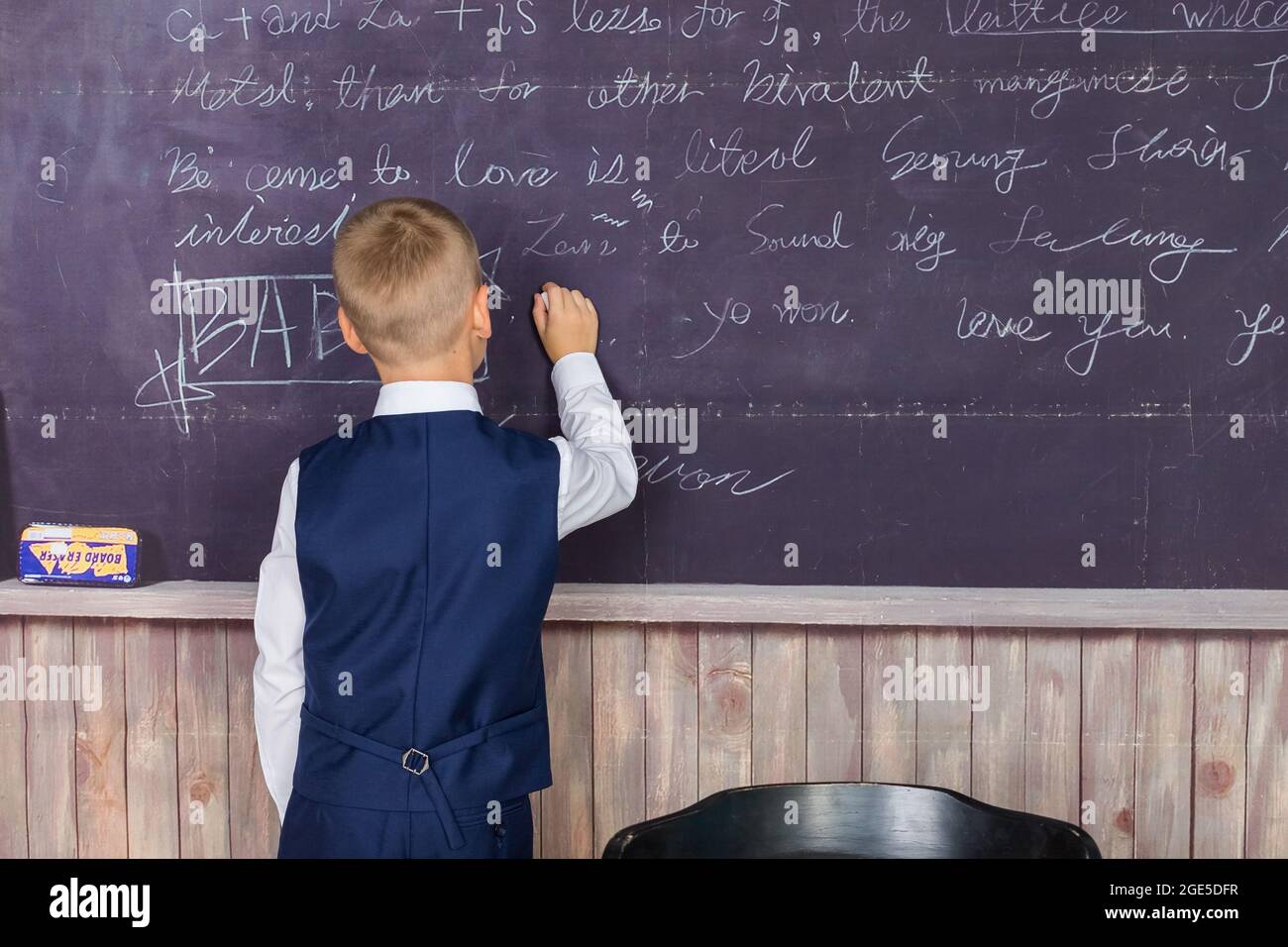 Back to school. Schoolchild in class.Child writing on chalkboard ...