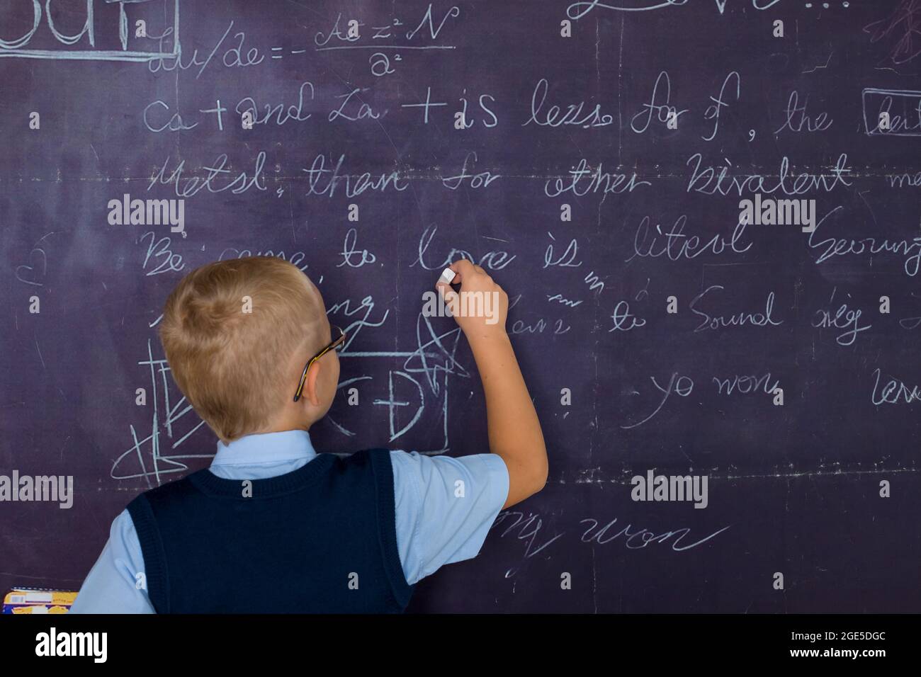 Back to school. Schoolchild in class.Child writing on chalkboard ...