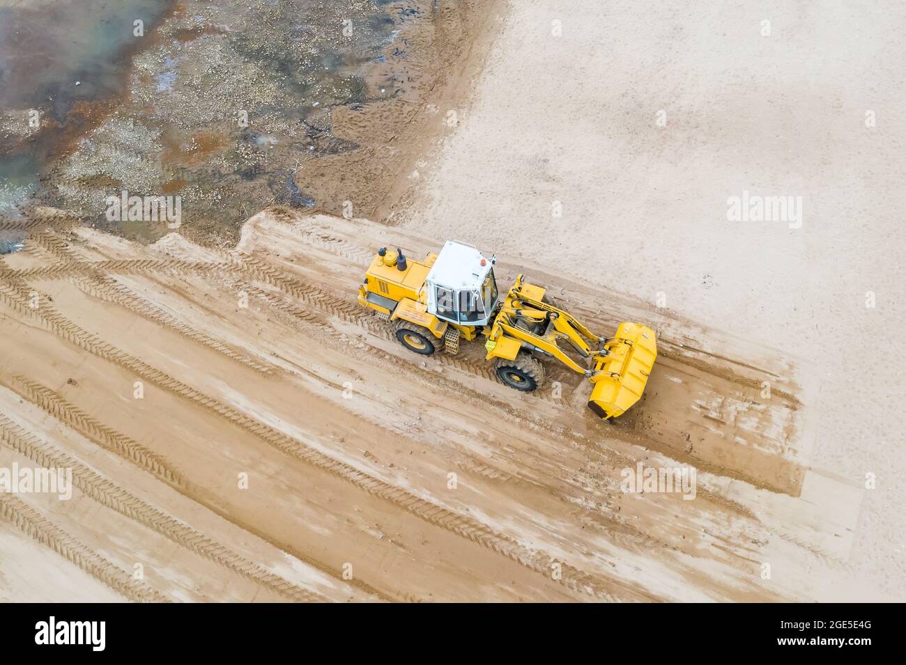 Aerial view of the working earth mover grader flattens the surface ...