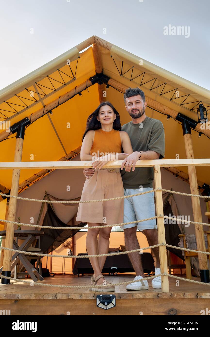 Amorous couple enjoying their honeymoon by glamping house at summer ...