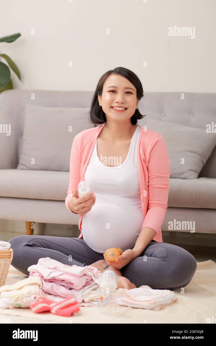 Pregnant woman is packing suitcase for maternity hospital getting ready ...