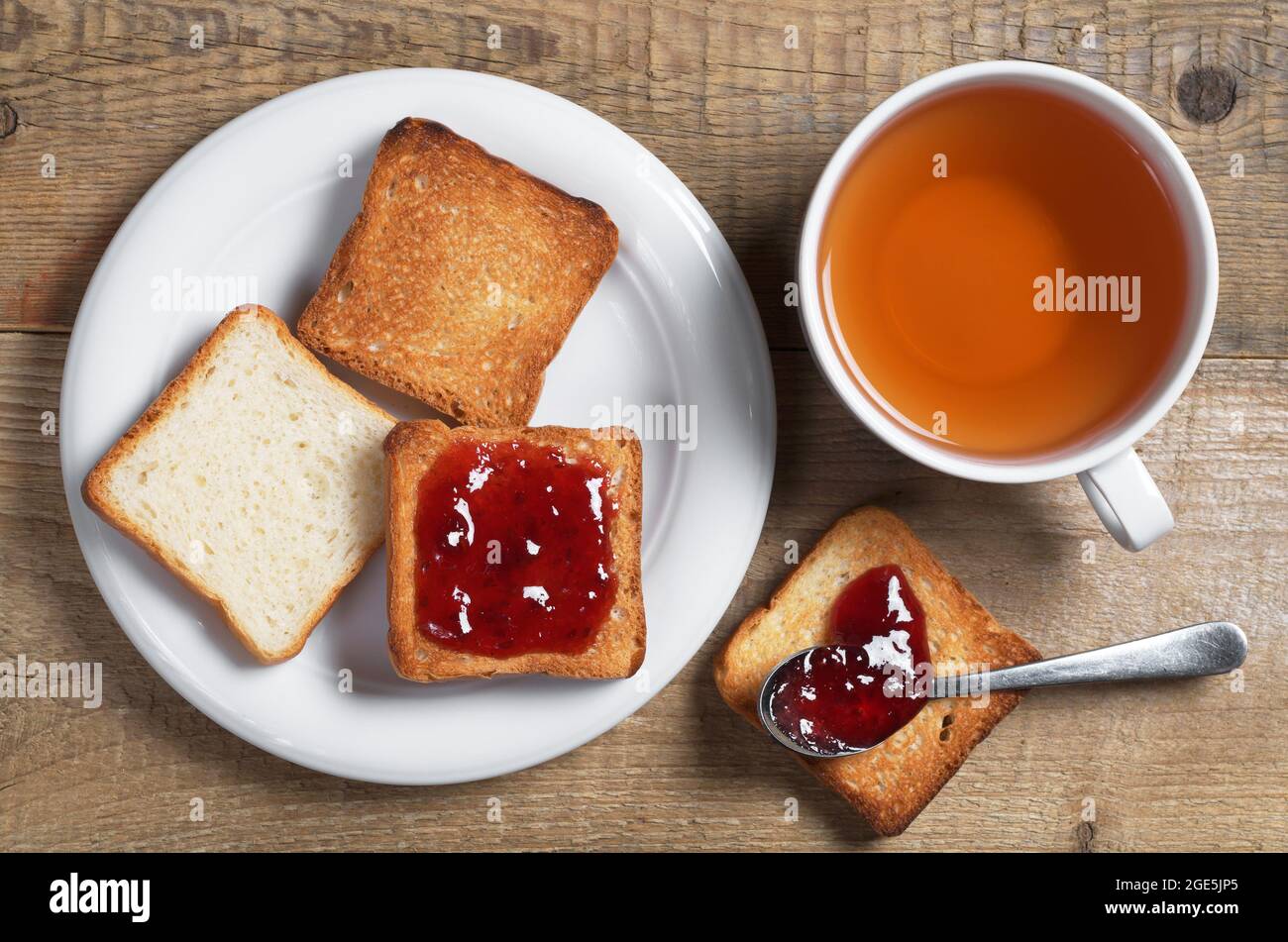 Cup of tea and small toast bread (white, roasted and with jam) on old ...