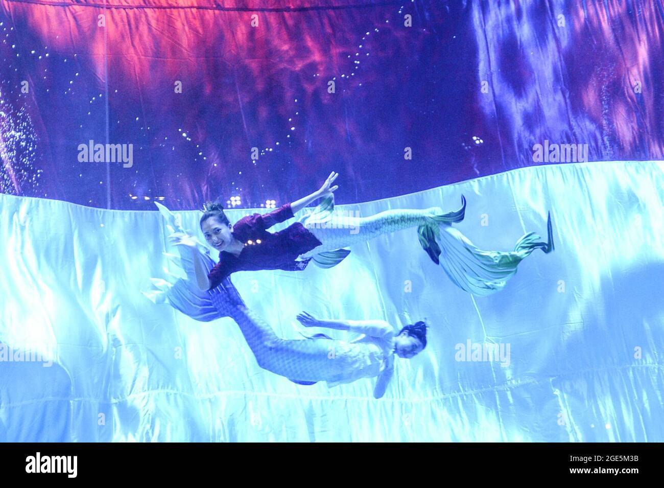 Jakarta, Indonesia. 17th Aug, 2021. Divers in mermaid costume perform ...