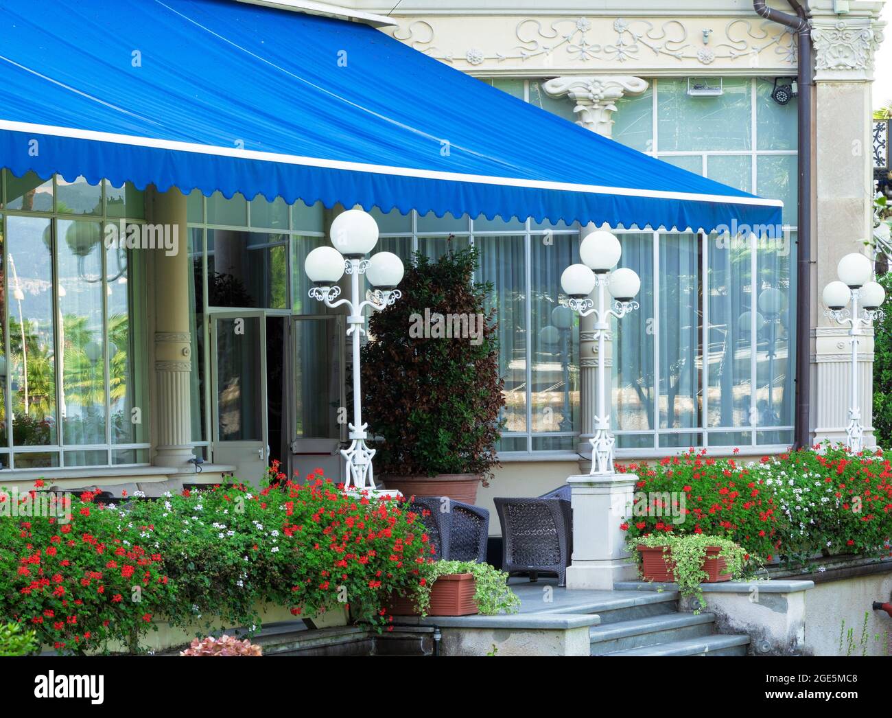 elegant terrace of a café bordered by flowering hedges Stock Photo - Alamy