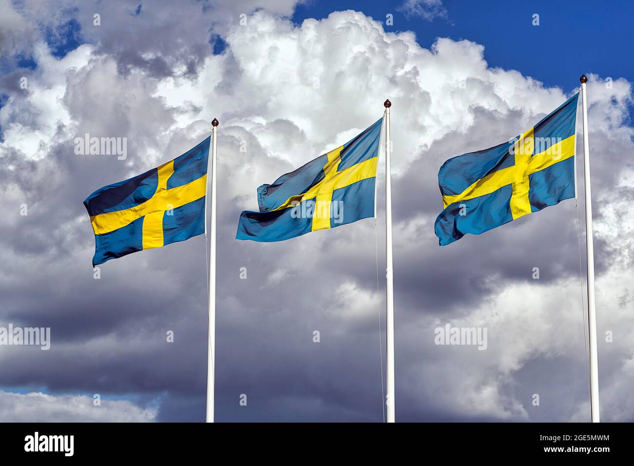 Three Swedish flags, national flags side by side, dramatic clouds ...