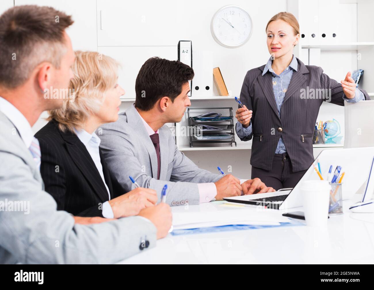 Female chief gathering managers for meeting Stock Photo - Alamy
