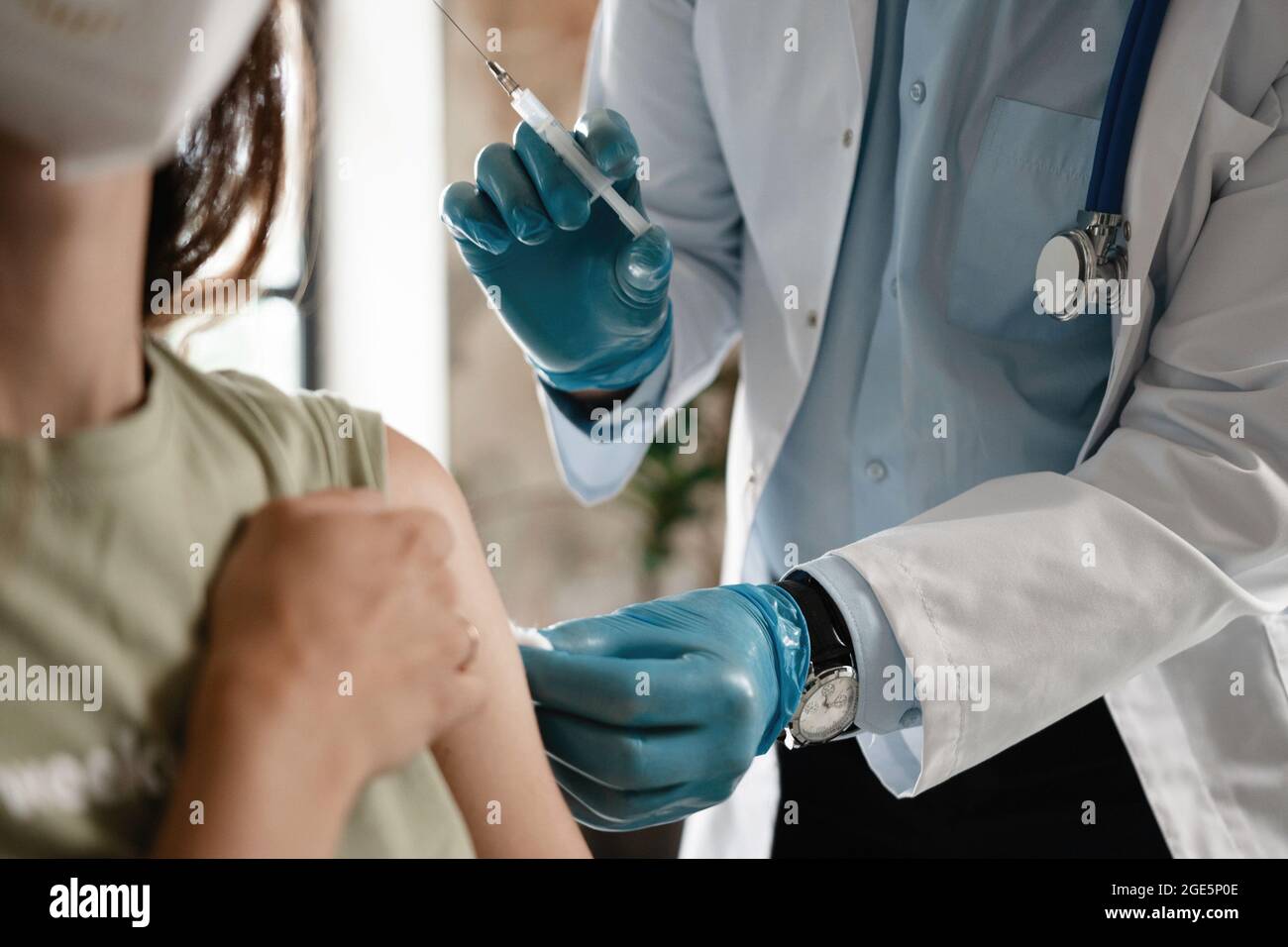 Closeup of a nervous woman and her doctor wearing face masks and ...