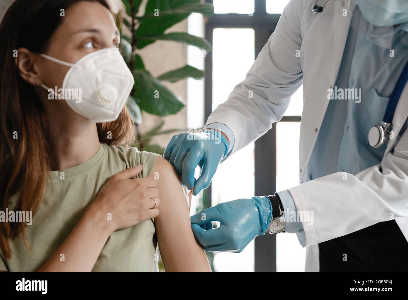 Closeup of a nervous woman and her doctor wearing face masks and ...