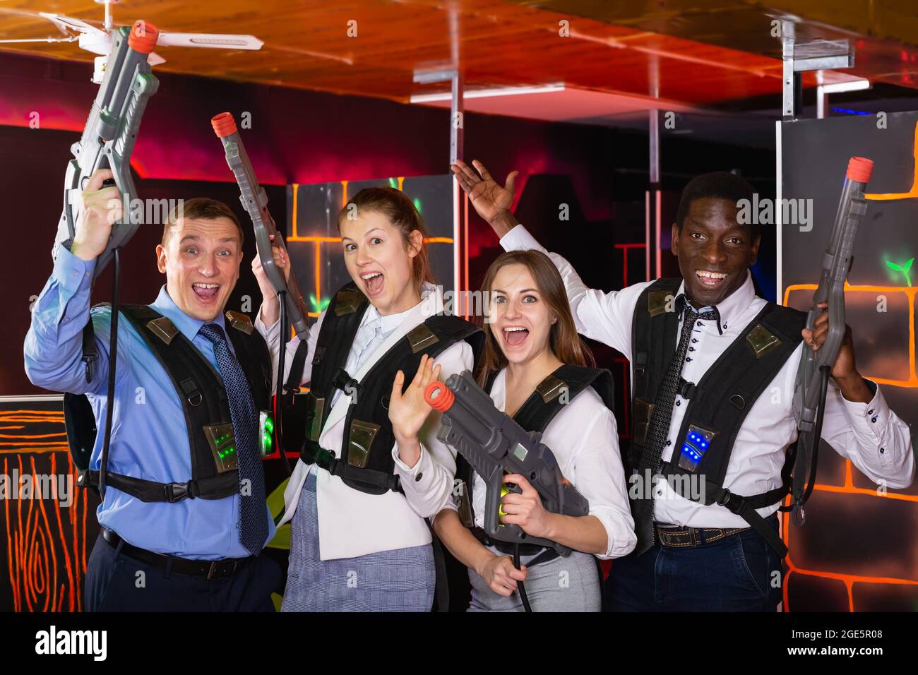 Group of jolly co-workers holding laser guns Stock Photo - Alamy