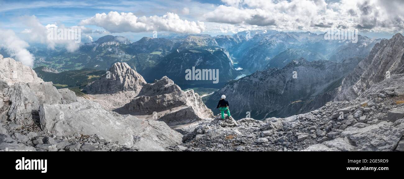 Hiker with helmet at the summit of the Watzmann middle peak, view over ...