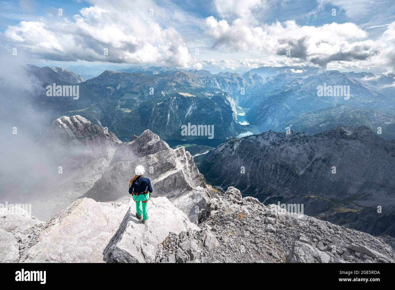 Hiker with helmet at the summit of the Watzmann middle peak, view over ...
