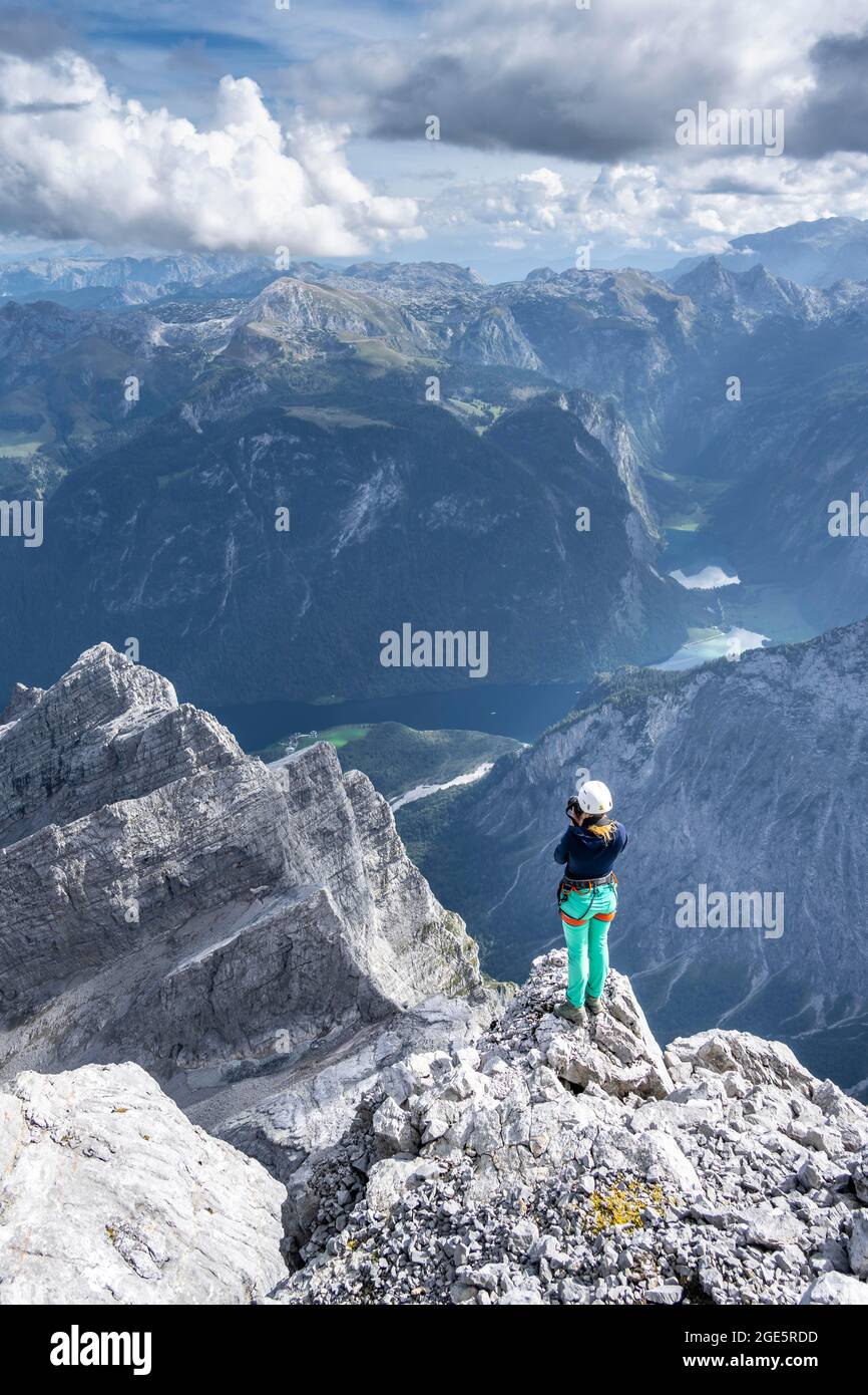 Hiker with helmet at the summit of the Watzmann middle peak, view over ...