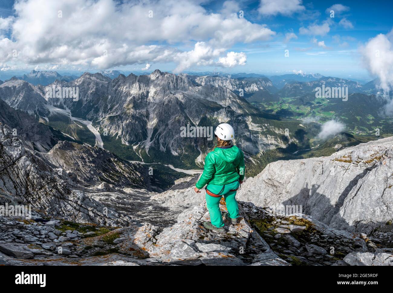 Hiker with helmet at the summit of the Watzmann, view over mountains ...