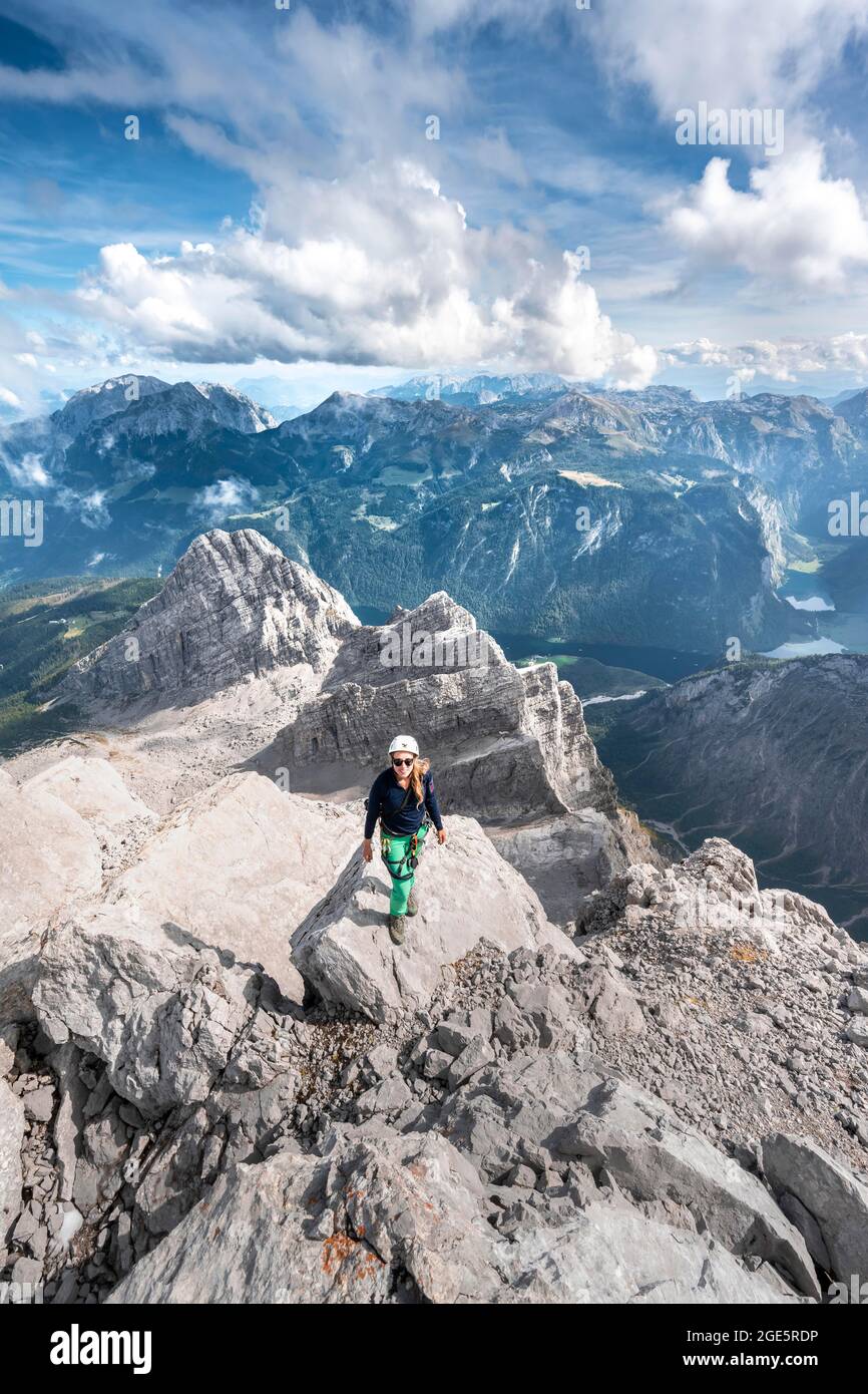 Hiker with helmet at the summit of the Watzmann middle peak, view over ...