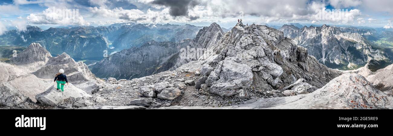 Hiker with helmet at the summit of the Watzmann middle peak, view over ...
