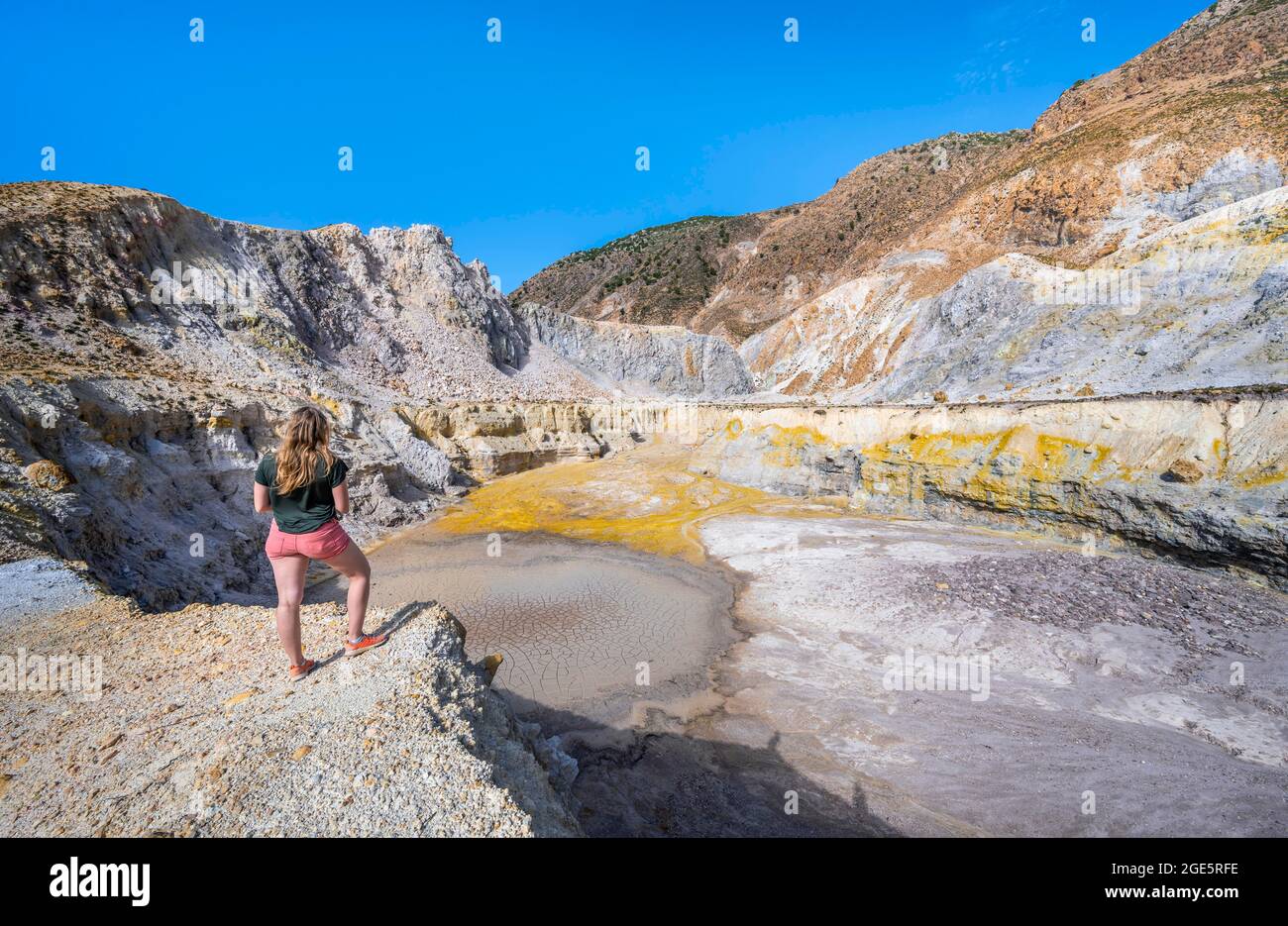 Young tourist at a crater, volcano caldera with pumice fields, yellow ...