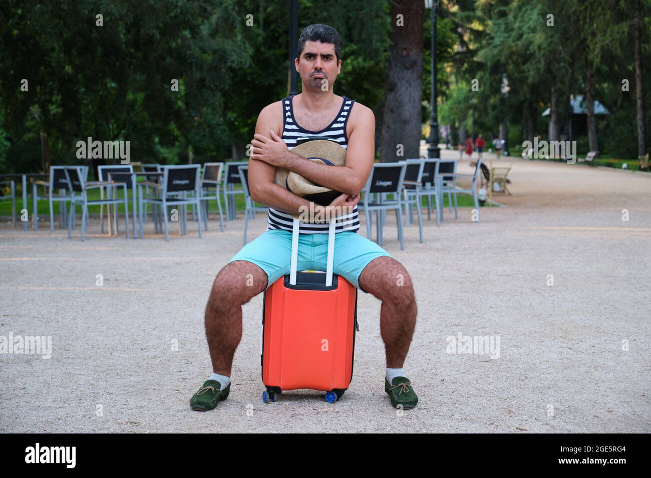 Tourist man sad because summer vacation is over, sitting on suitcase in ...