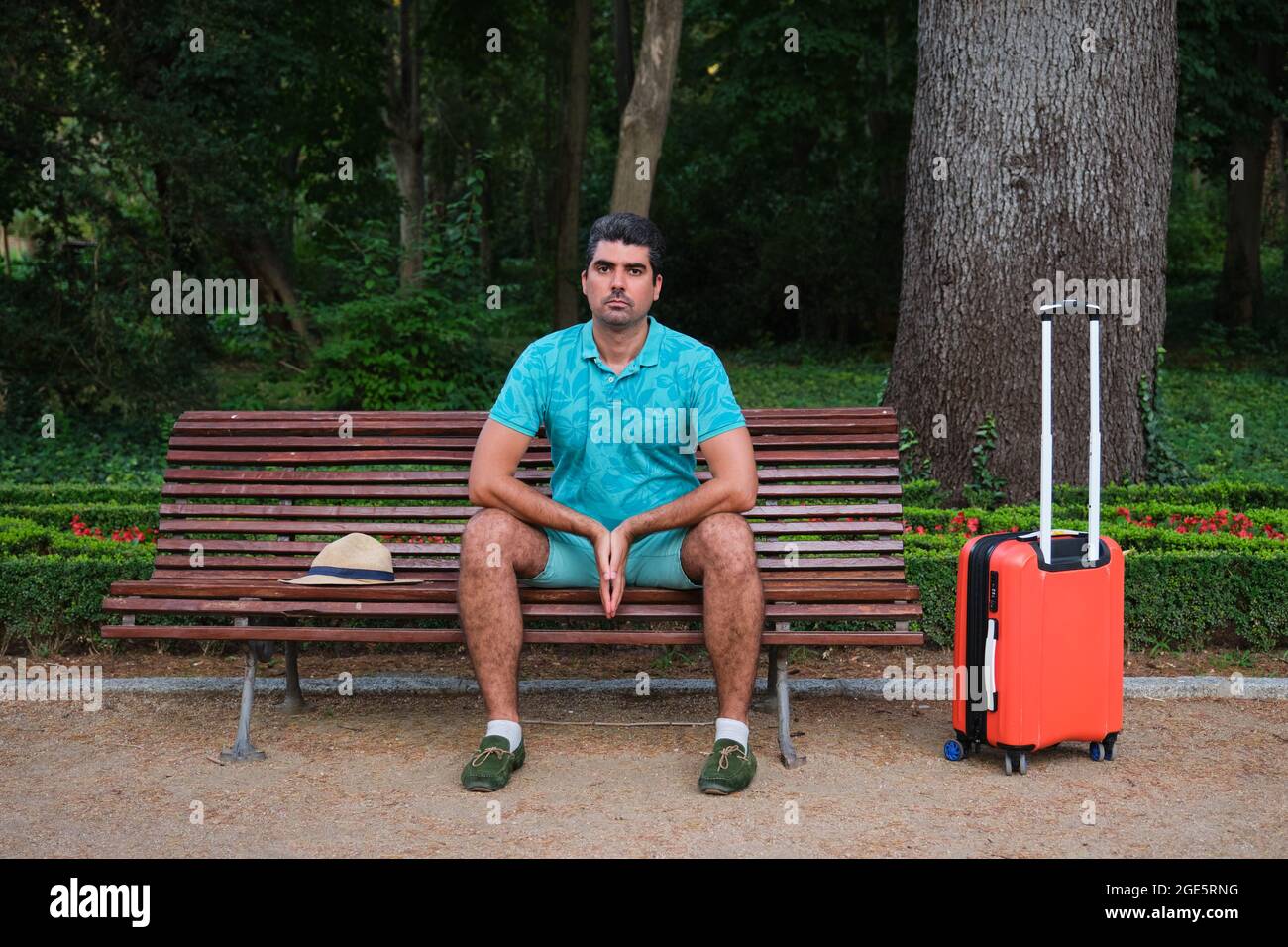 Tourist man sitting on a bench waiting for someone Stock Photo - Alamy