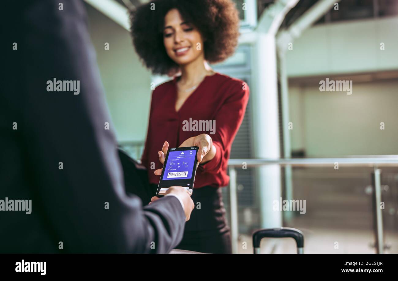 Woman traveler boarding to the plane showing smart phone ticket at the ...