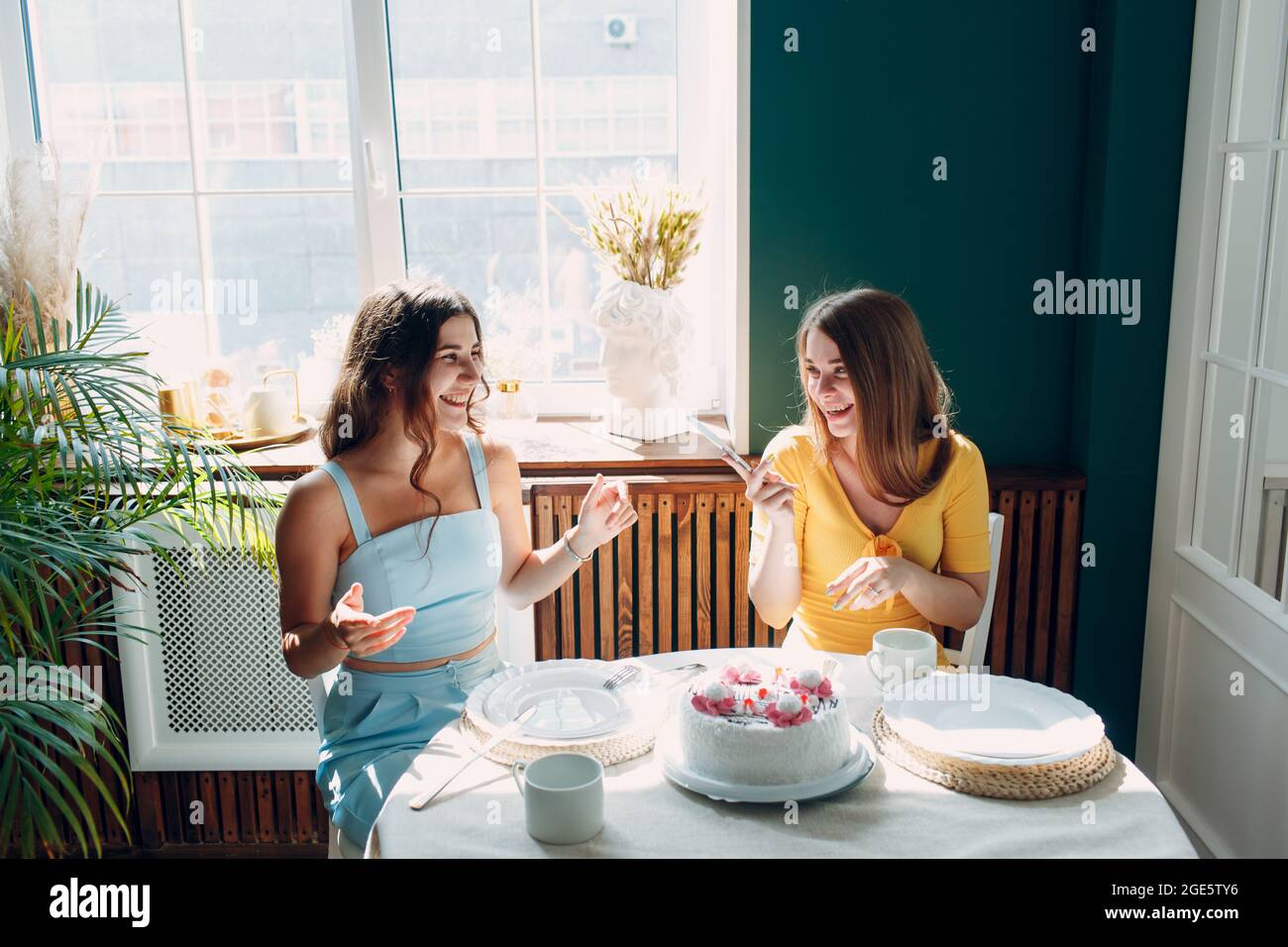 Women happy friends at home sitting and smiling with white birthday ...