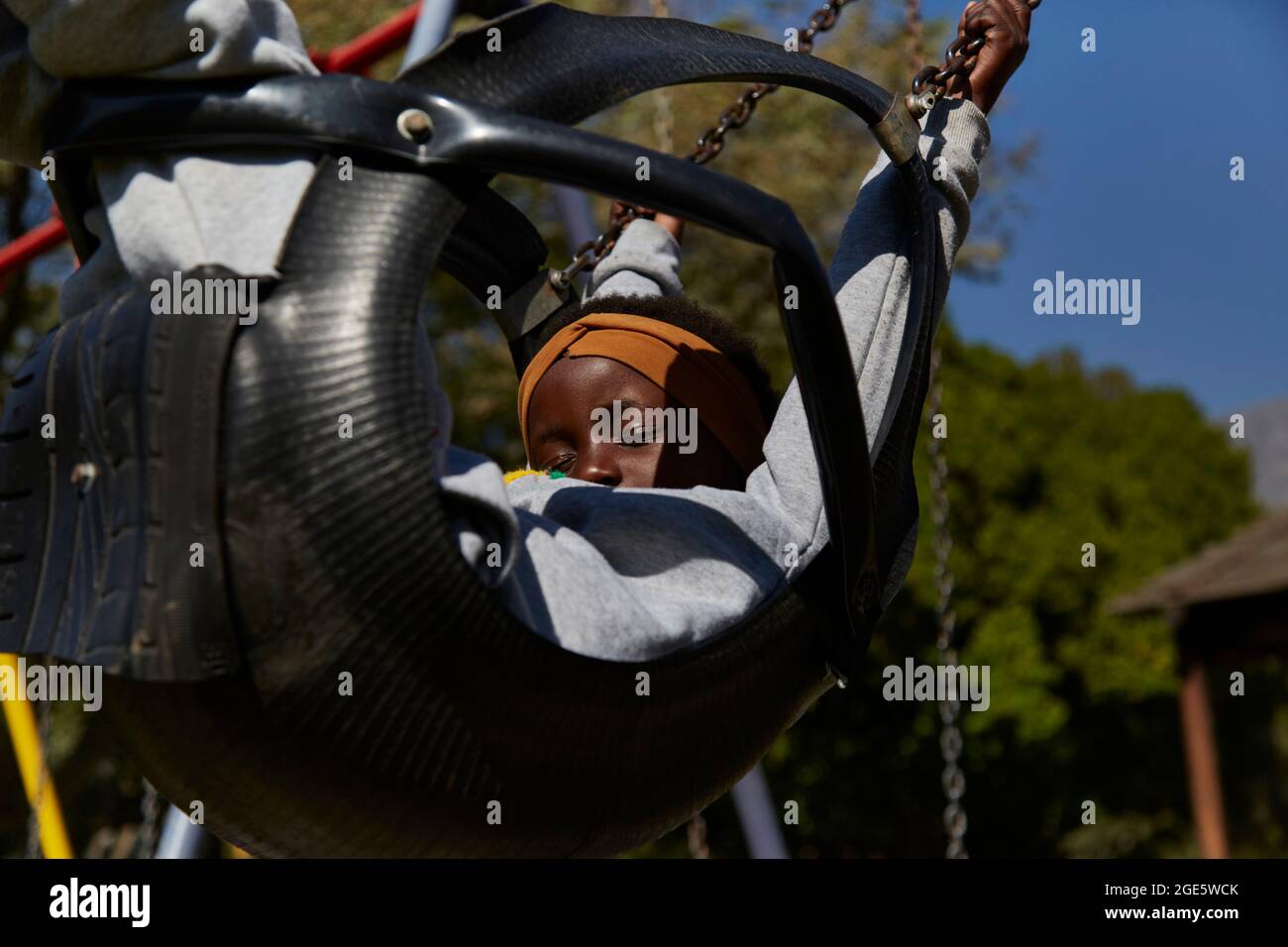 Beautiful black african girl on swings in park Stock Photo - Alamy
