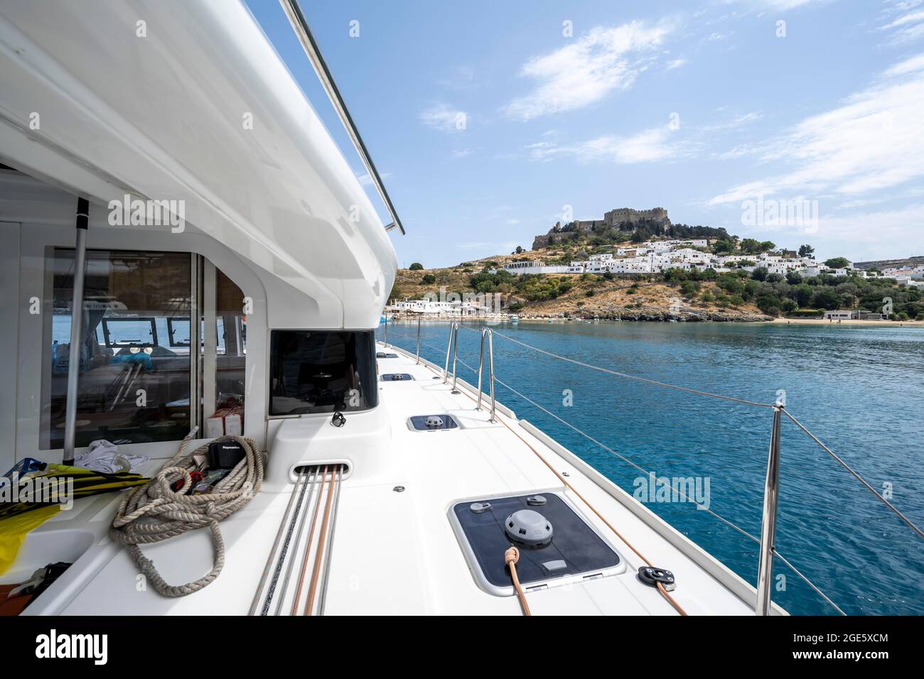 Deck of a sailing catamaran, Lindos and Acropolis of Lindos at the back ...