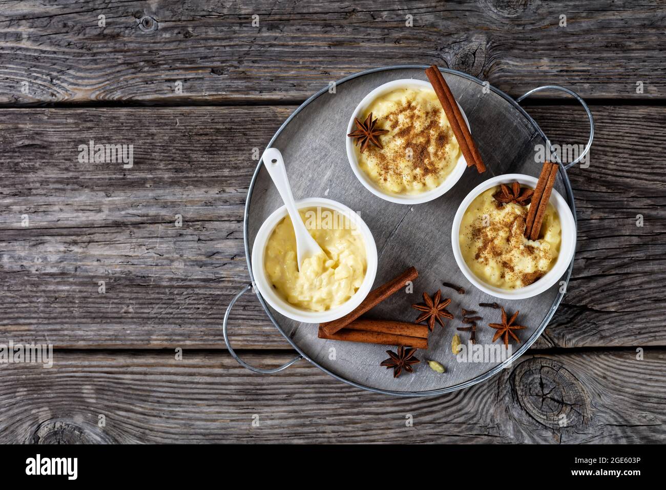 rice pudding with cinnamon and anise star in white bowls with ...