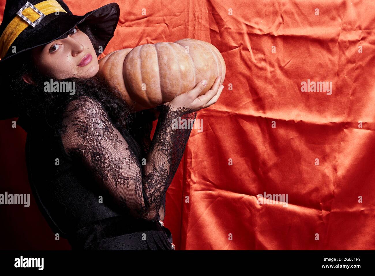 Halloween lady wearing witch cup and holding a big Halloween pumpkin. A ...