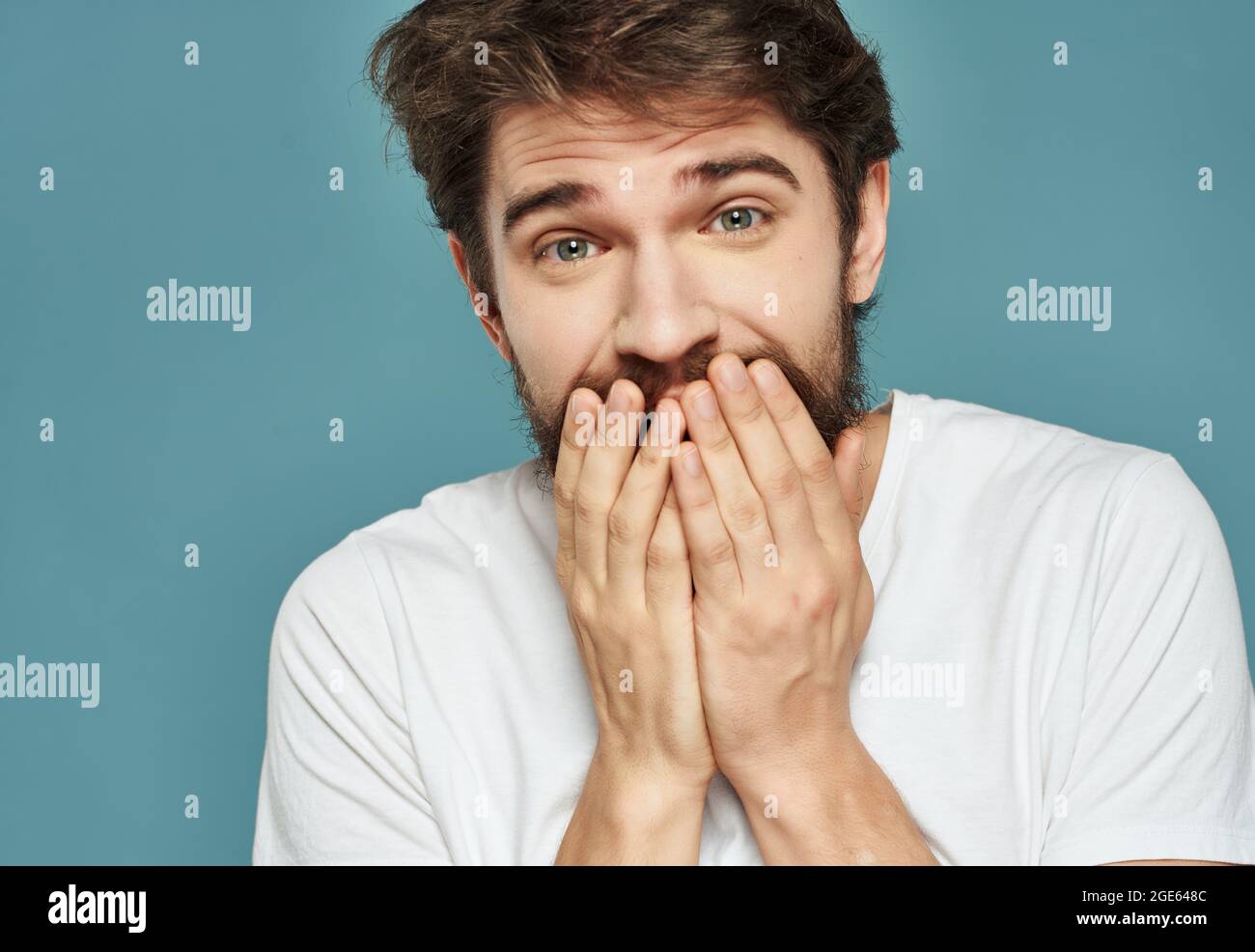 Man in a white t-shirt hand gestures anger blue background Stock Photo ...