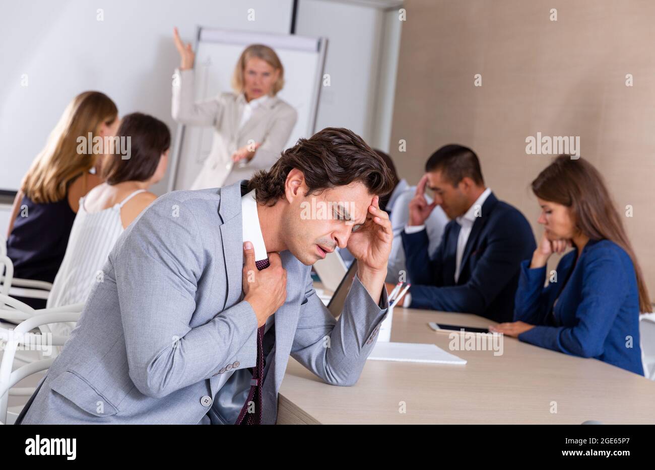 Tired adult businessman on meeting Stock Photo - Alamy