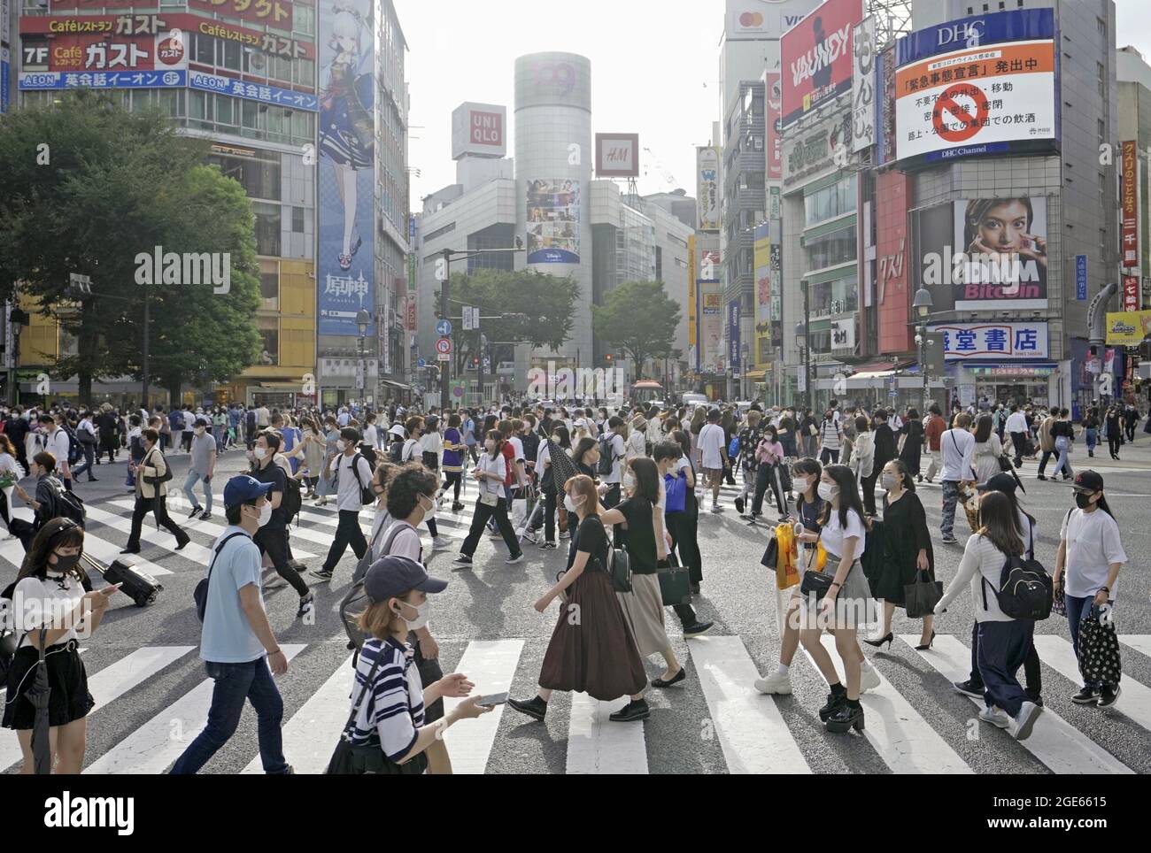 People wearing masks for protection against the coronavirus walk at the ...