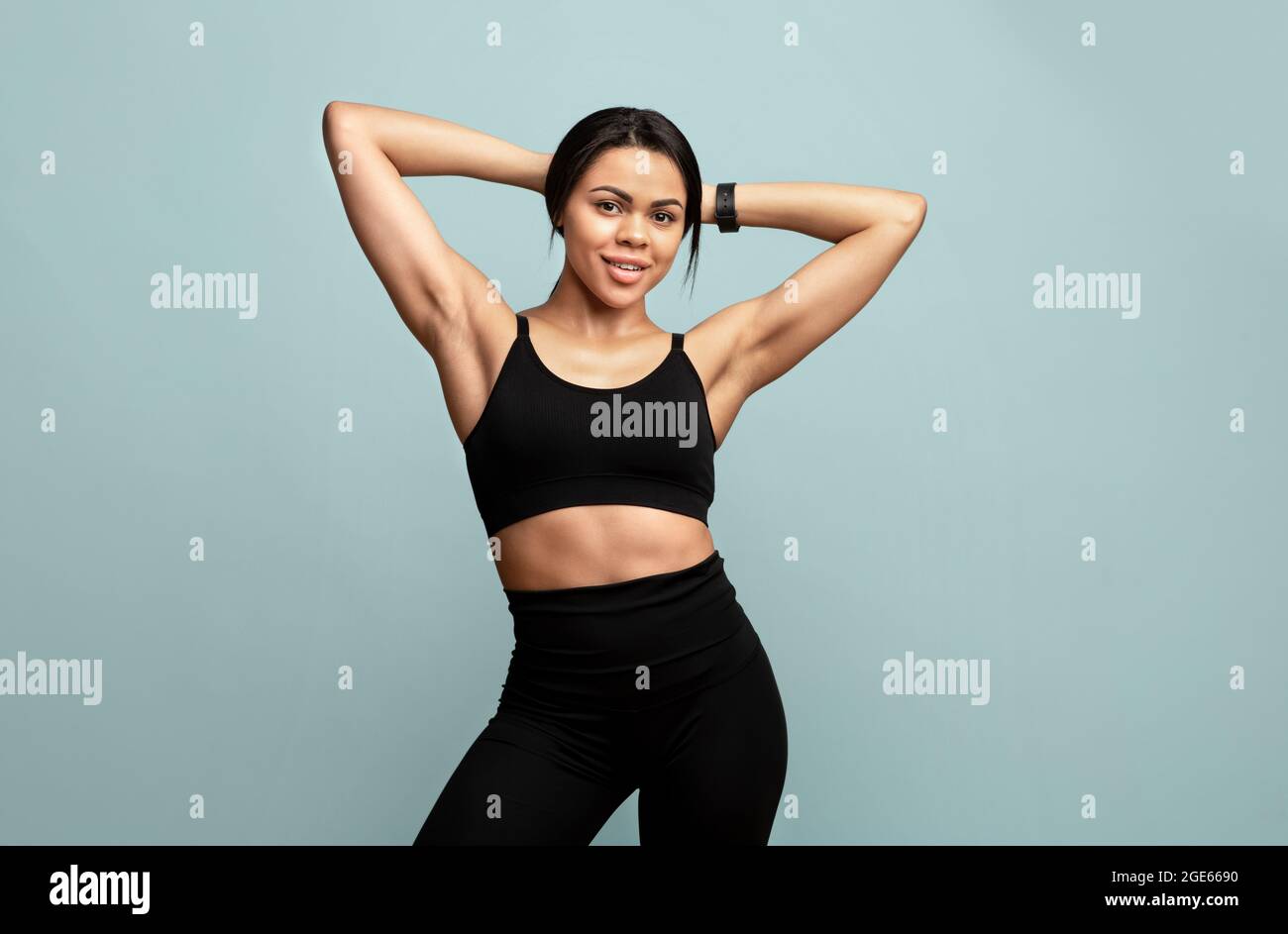 Active lifestyle, fit body. Attractive black lady in sportswear raising ...