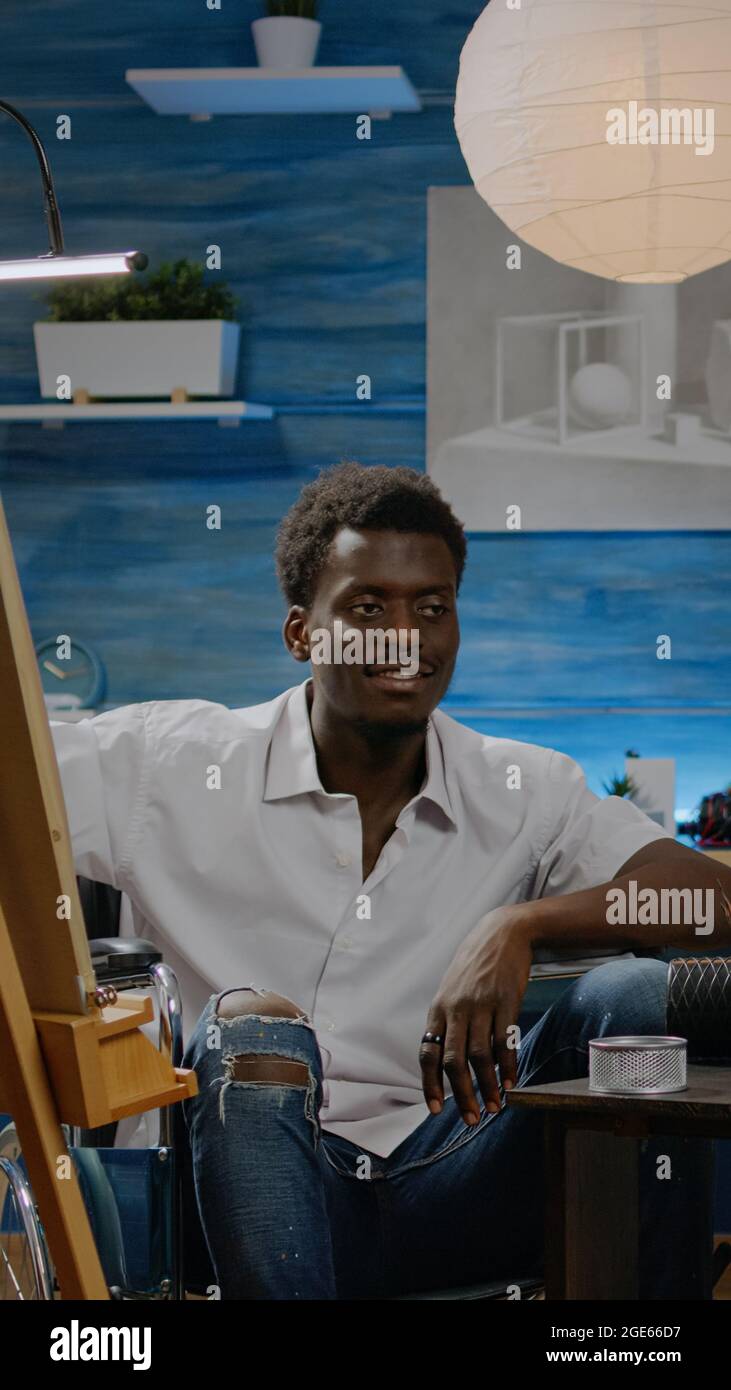 Black person in wheelchair designing vase drawing in artwork studio ...