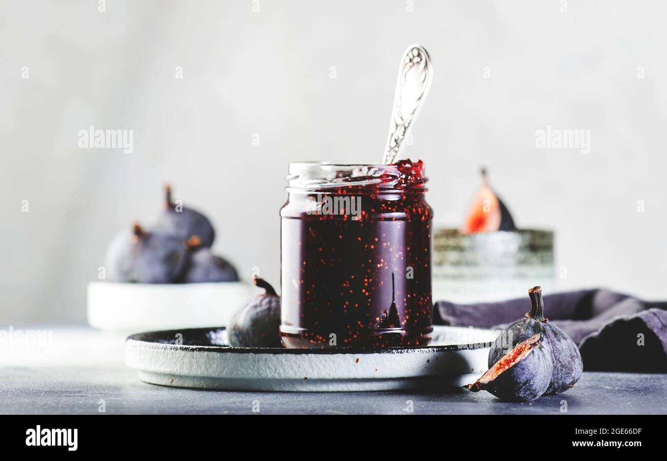 Fig confiture in glass jar. Fresh fruits on gray kitchen table ...