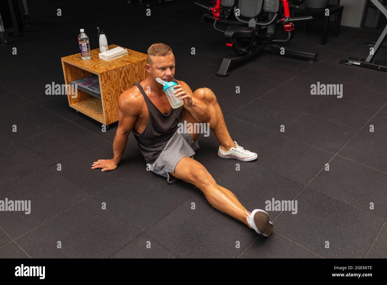 Young caucasian man drinking water after exercise.man in the gym ...