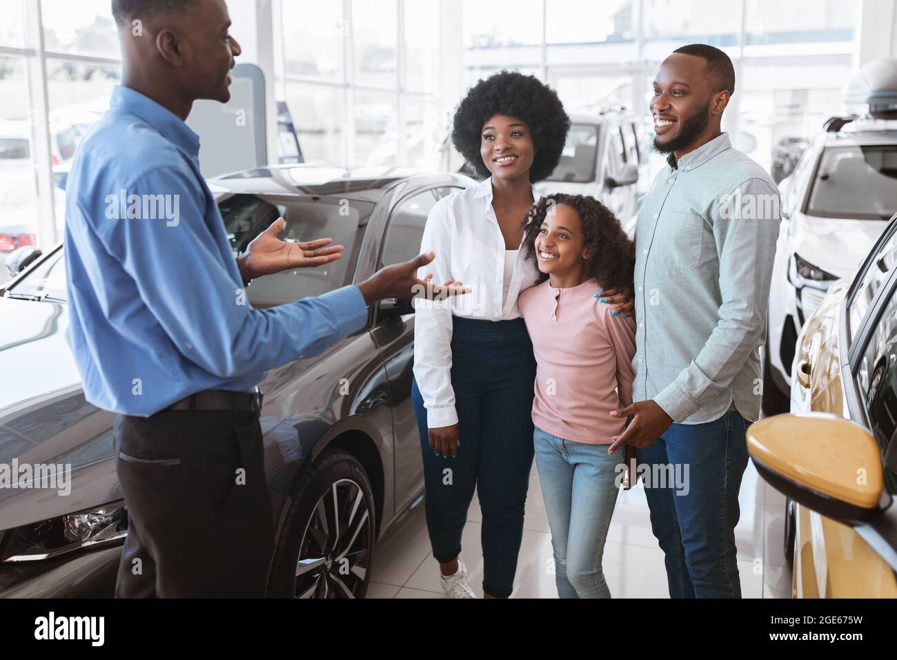 Car selling business. Confident manager showing luxury automobile to ...