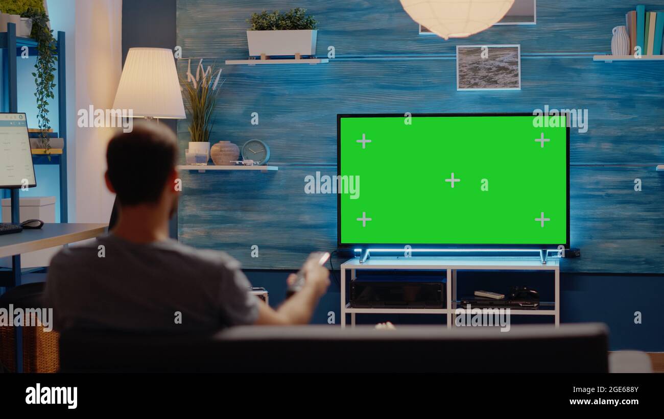 Caucasian man switching channels on green screen television display in ...