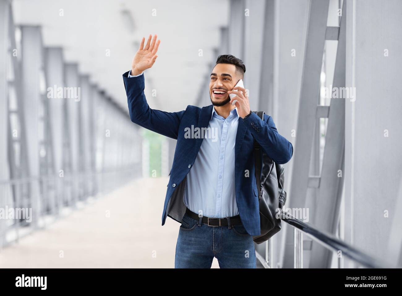 Hello. Happy Arab Man Waving Hand And Talking On Cellphone While ...