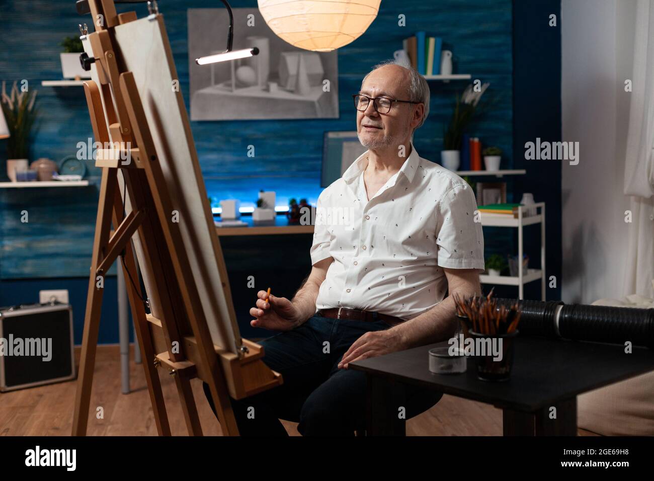 Caucasian senior man working as artist with canvas and easel for ...