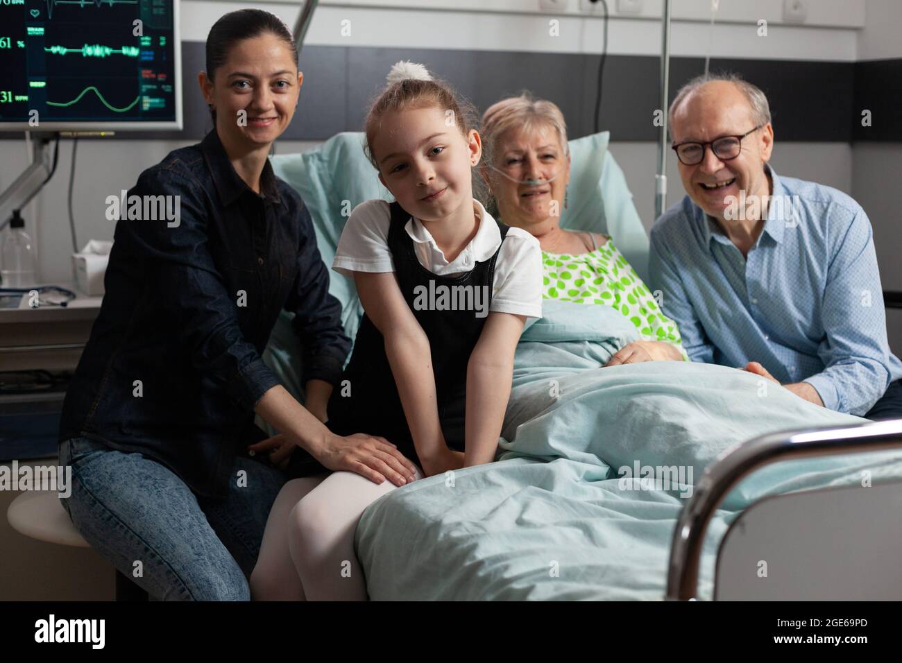 Portrait of family sitting with sick retired grandmother visiting her ...