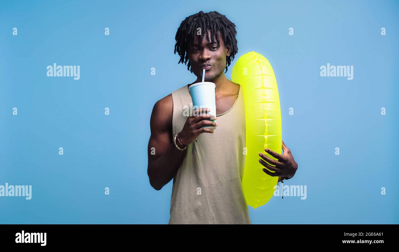 African american man with paper cup drinking soft drink and holding ...