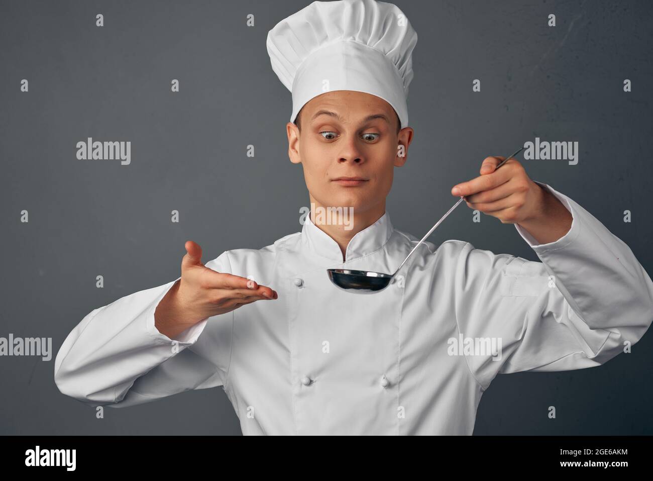 Cheerful chef with a ladle in his hands, professional cooking Stock ...