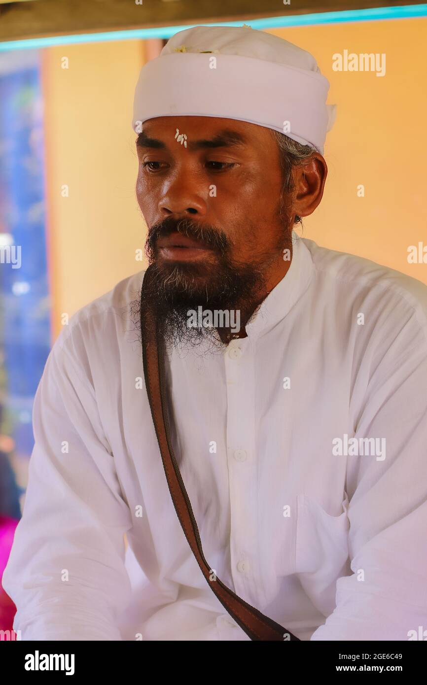 Balinese priest in traditional clothes performing The Melaspas Ceremony ...
