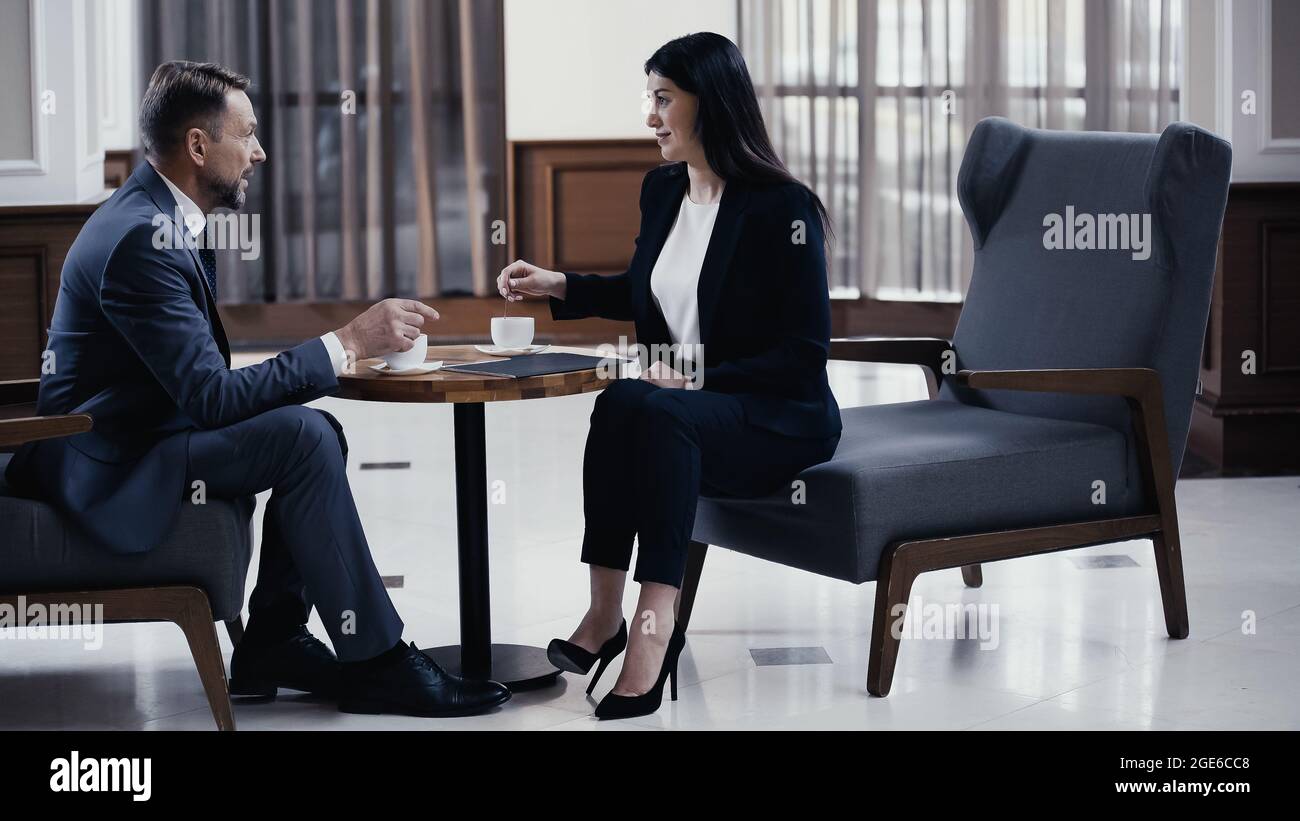 Business partners talking over coffee in restaurant lobby,stock image ...